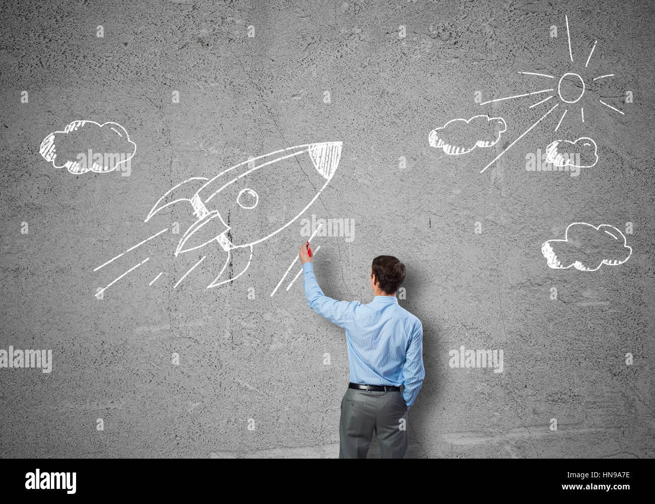 Rear view of businessman drawing rocket on wall Stock Photo - Alamy