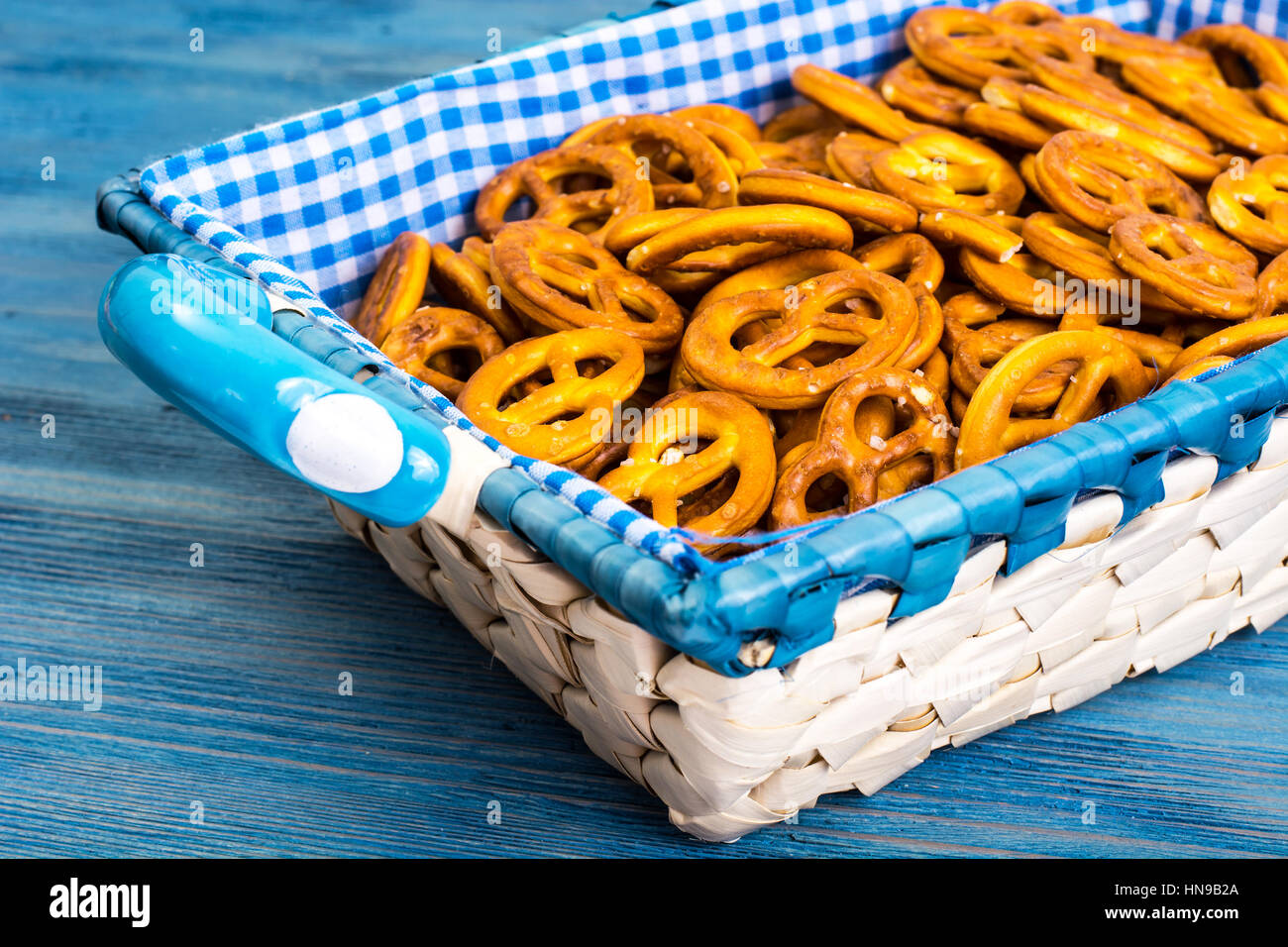 White wicker basket of bread with checkered cloth on blue backgr Stock ...