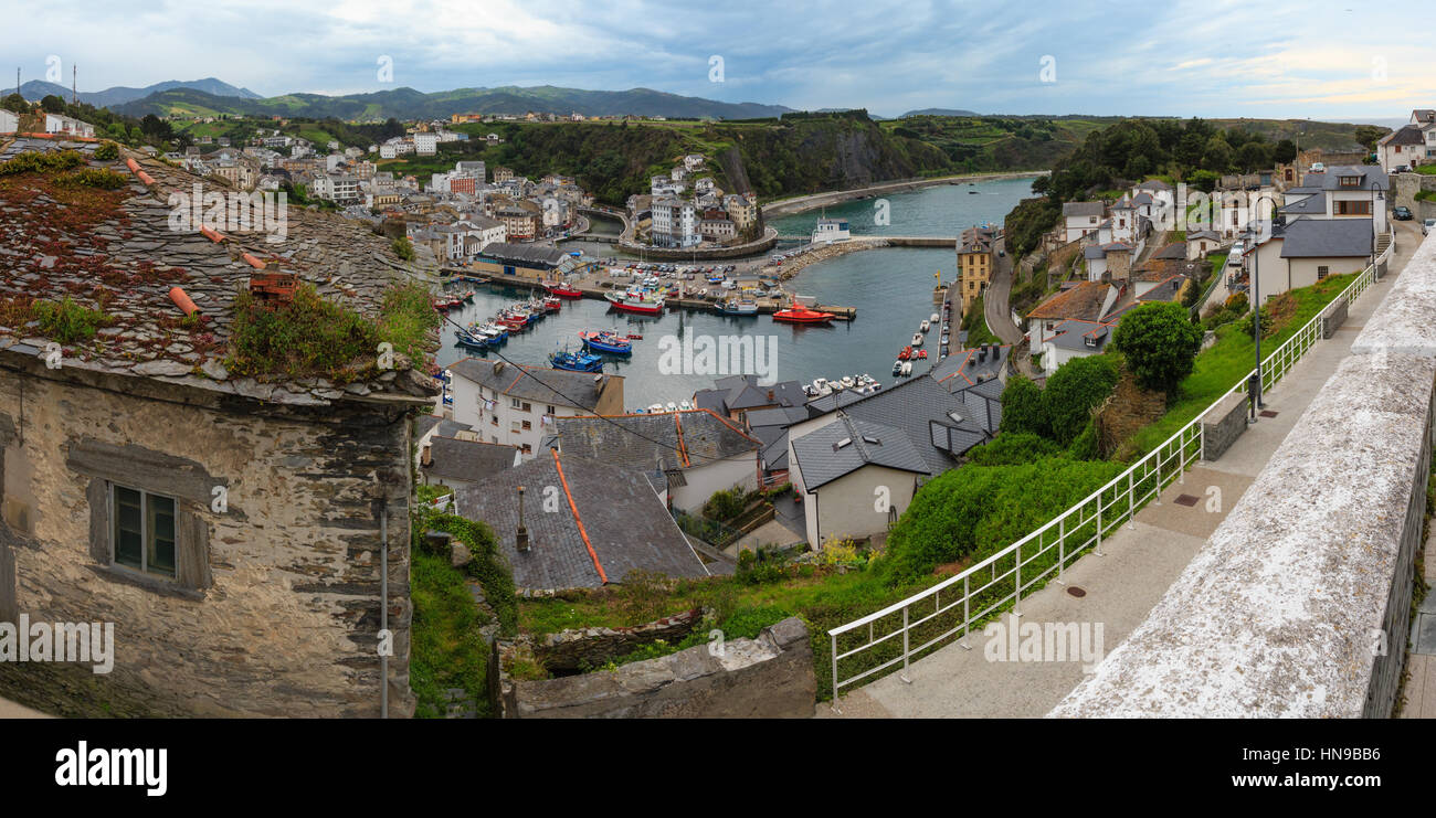 Evening Luarca cityscape (top view) with colorful boats in fishing port ...