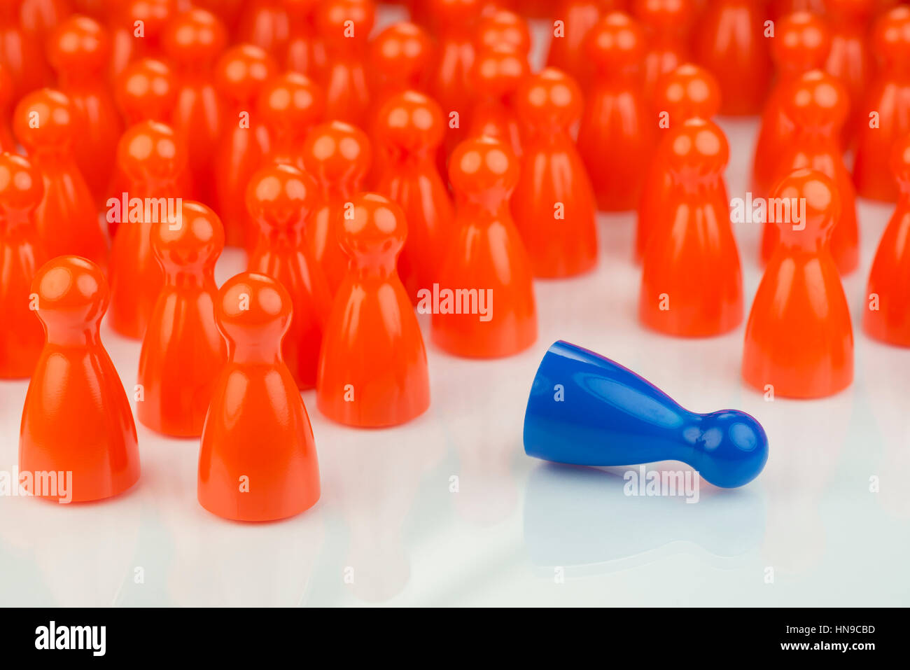 Conceptual orange game pawns and a blue play pawn as abstract display ...