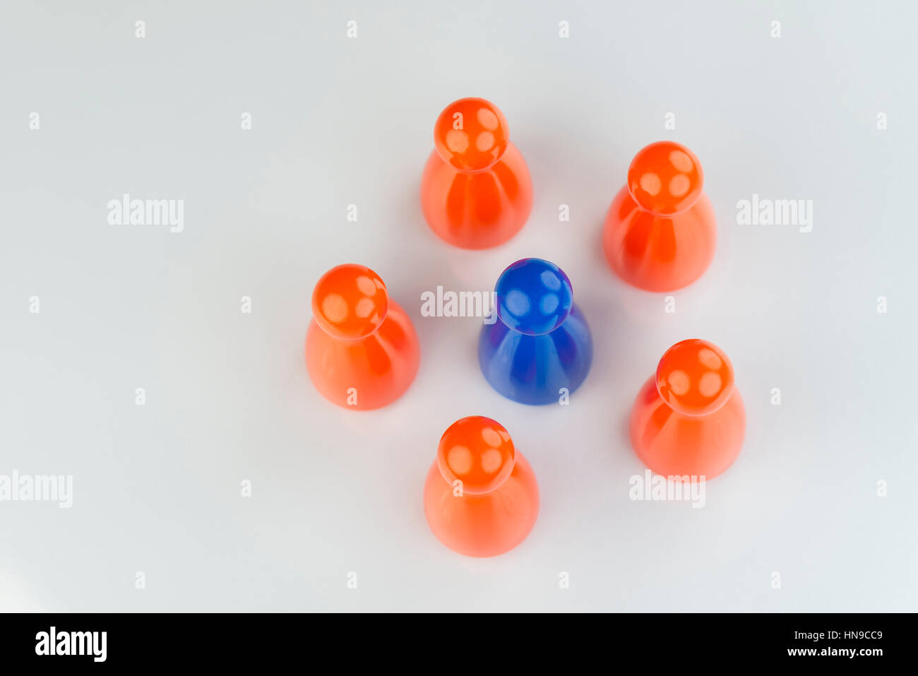 Conceptual orange game pawns and a blue play pawn as abstract display ...
