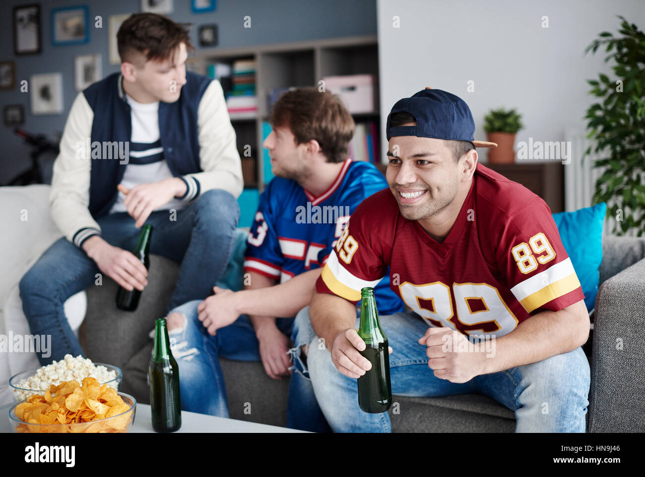 Three men sitting close hi-res stock photography and images - Alamy