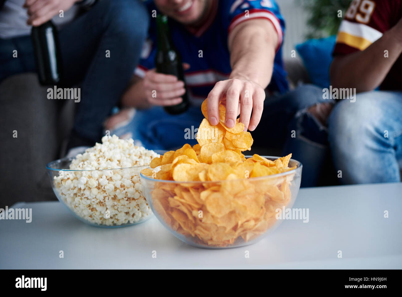 Close up of mens hand grabbing chips Stock Photo - Alamy