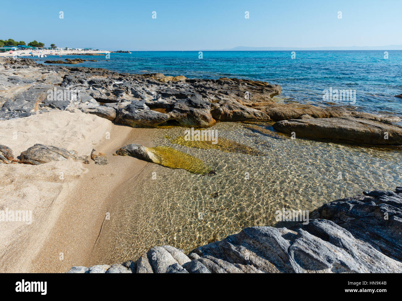 Summer morning sandy beach with camping and rocky coast near Platanitsi ...