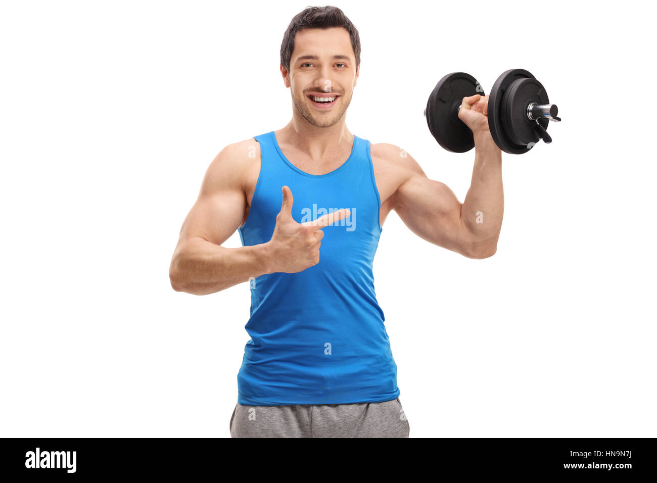 Happy young man lifting a dumbbell and pointing isolated on white ...