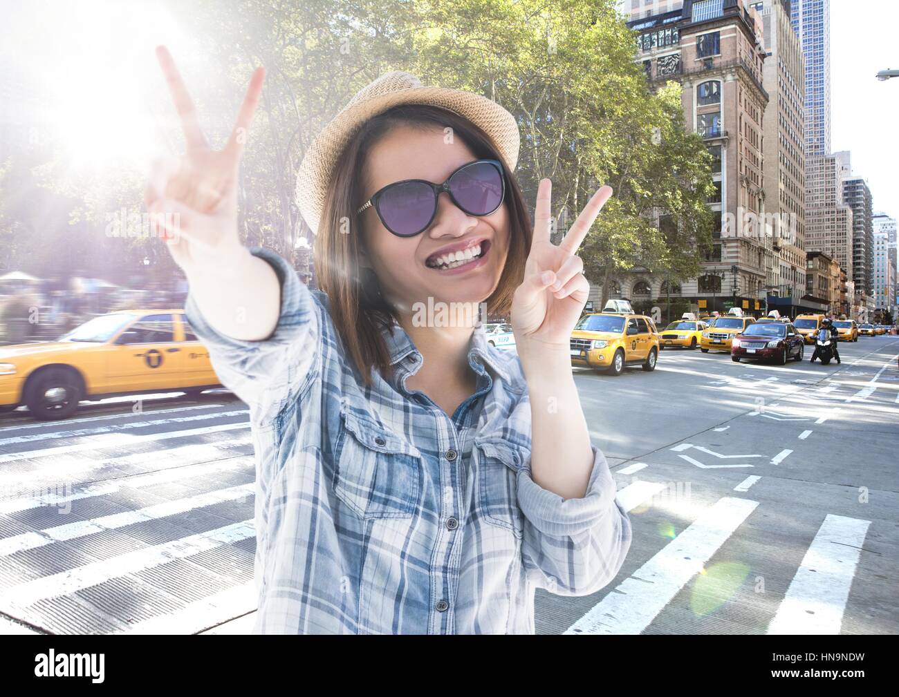 Digital composite of Woman doing peace sign on street with flare Stock ...
