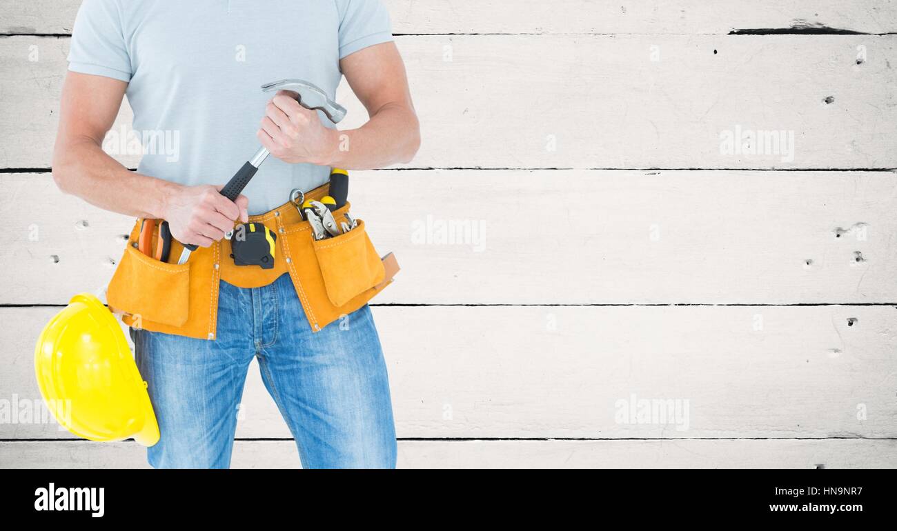 Digital composite of Carpenter with hammer against white wood panel ...