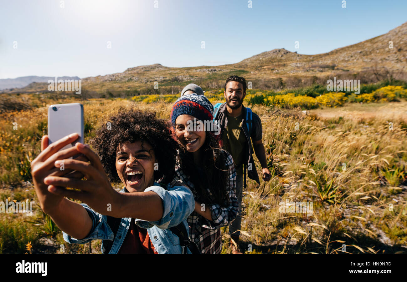 Group of friends taking selfie on country hike. Young people hiking in ...
