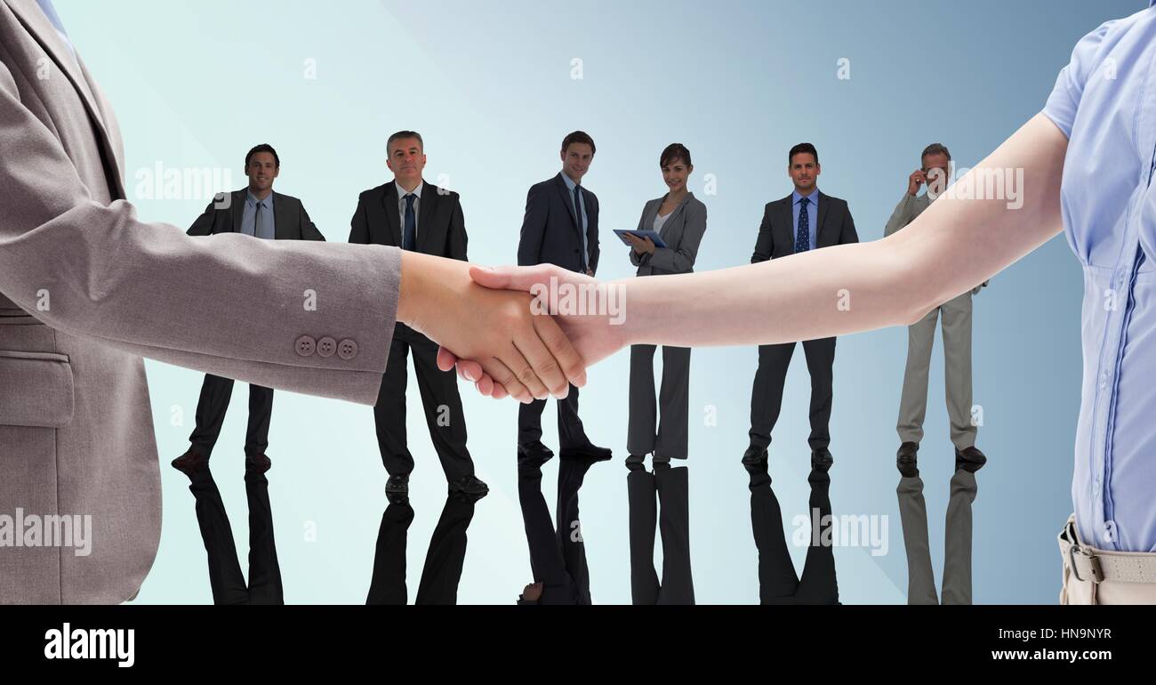 Digital composite of Handshake in front of business people with blue ...