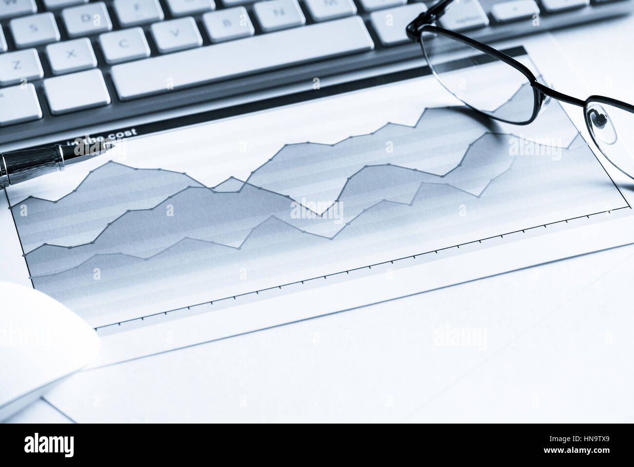 Business workplace with keyboard mouse and papers with graphs and ...