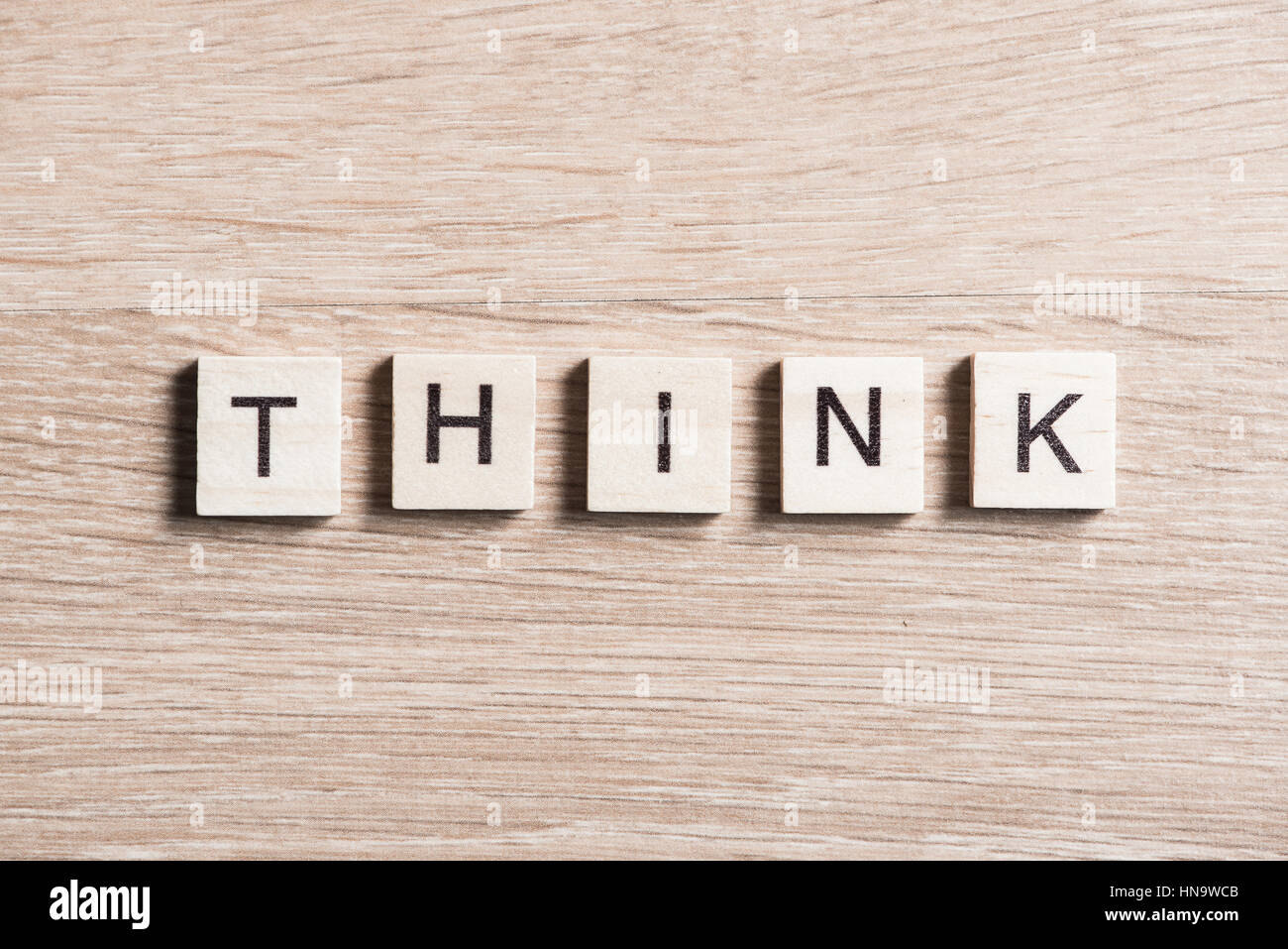 Wooden element on wooden table spelling word think Stock Photo - Alamy