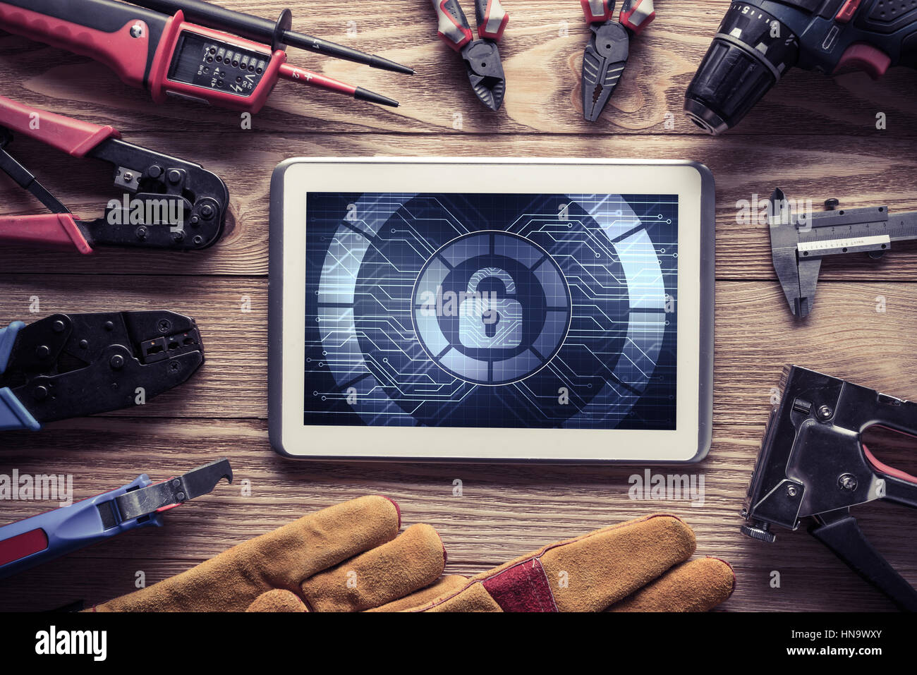 Tablet pc with security concept on screen and industrial tools around ...