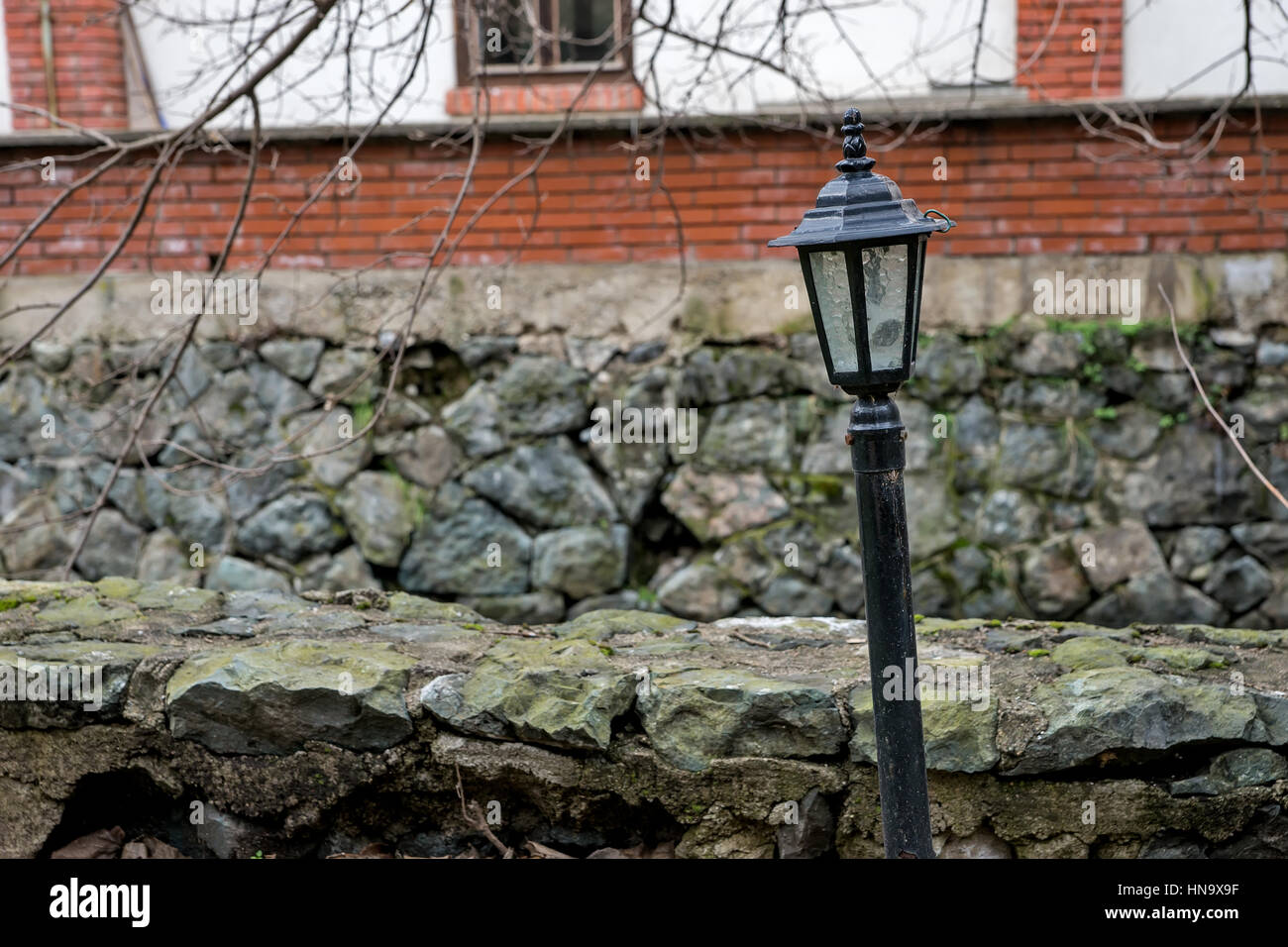 Crooked street lamp in front of a brick building Stock Photo - Alamy
