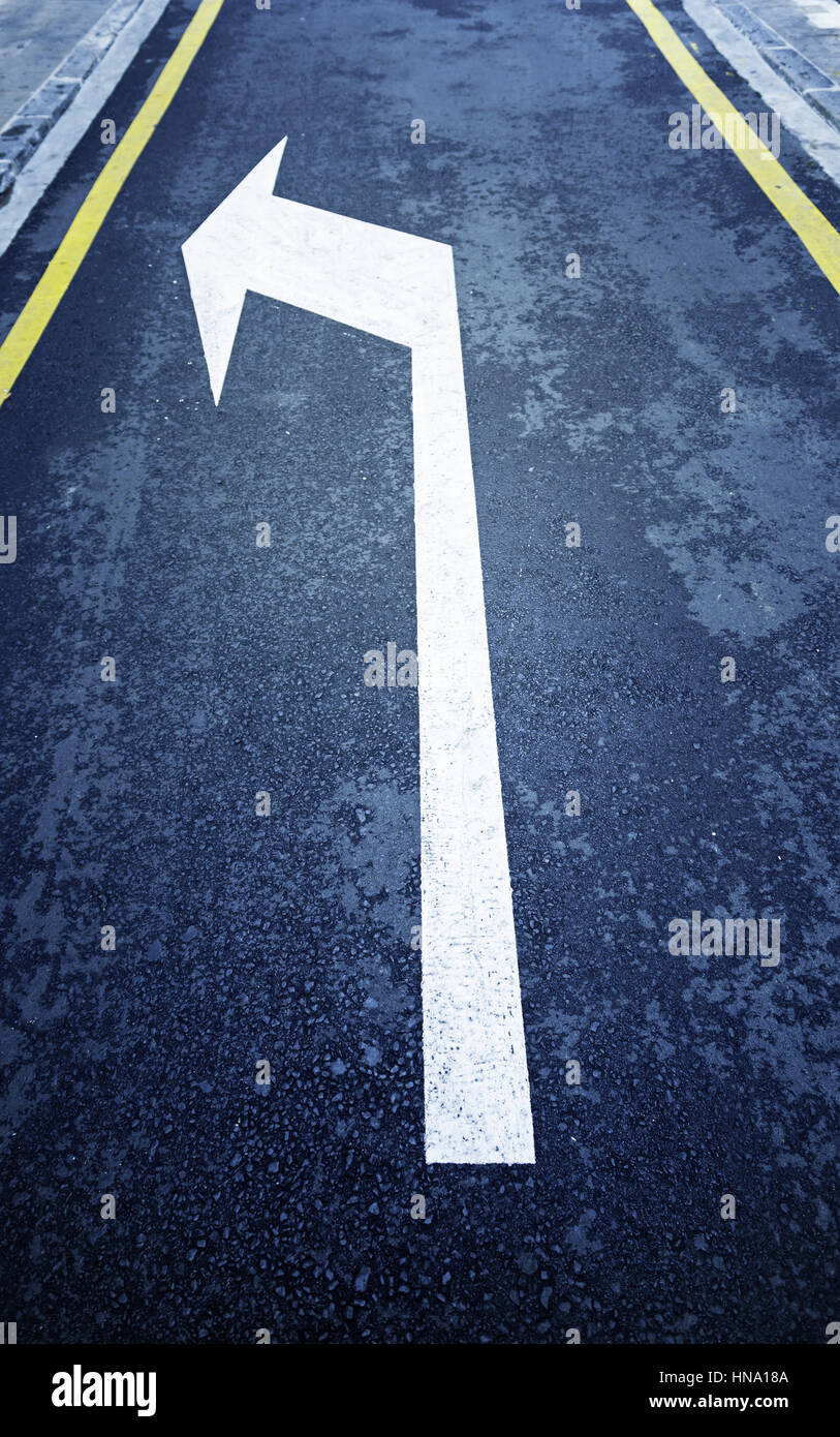 Arrow on the asphalt, detail of a traffic signal on the road, and ...