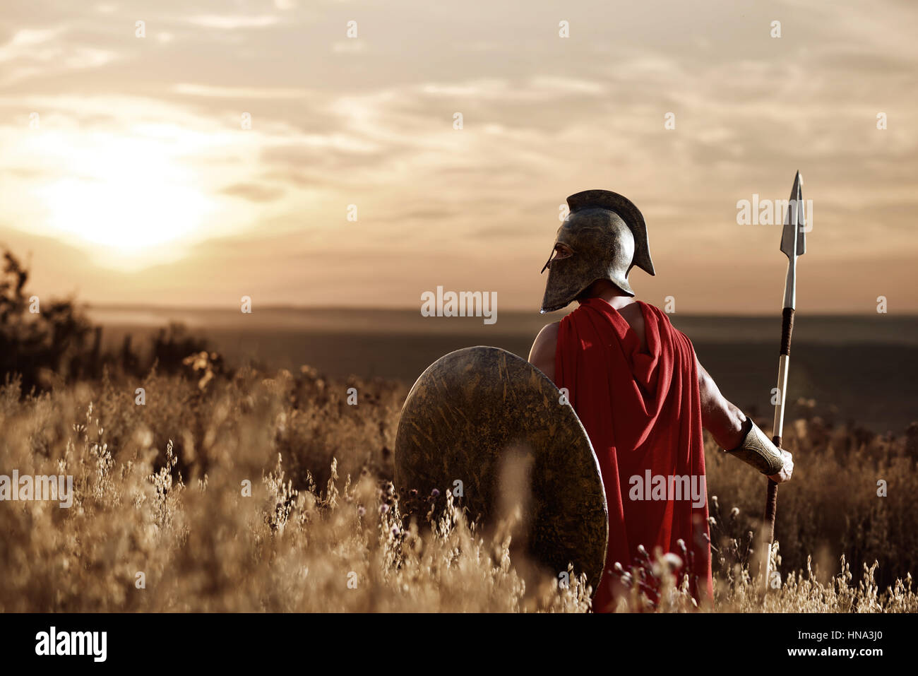 Warrior wearing iron helmet and red cloak Stock Photo - Alamy