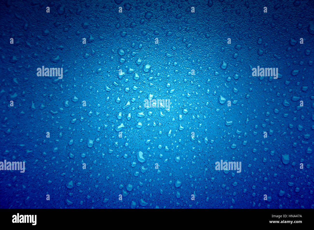 Water drops on blue, detail of a wet blue surface water, rain in the ...