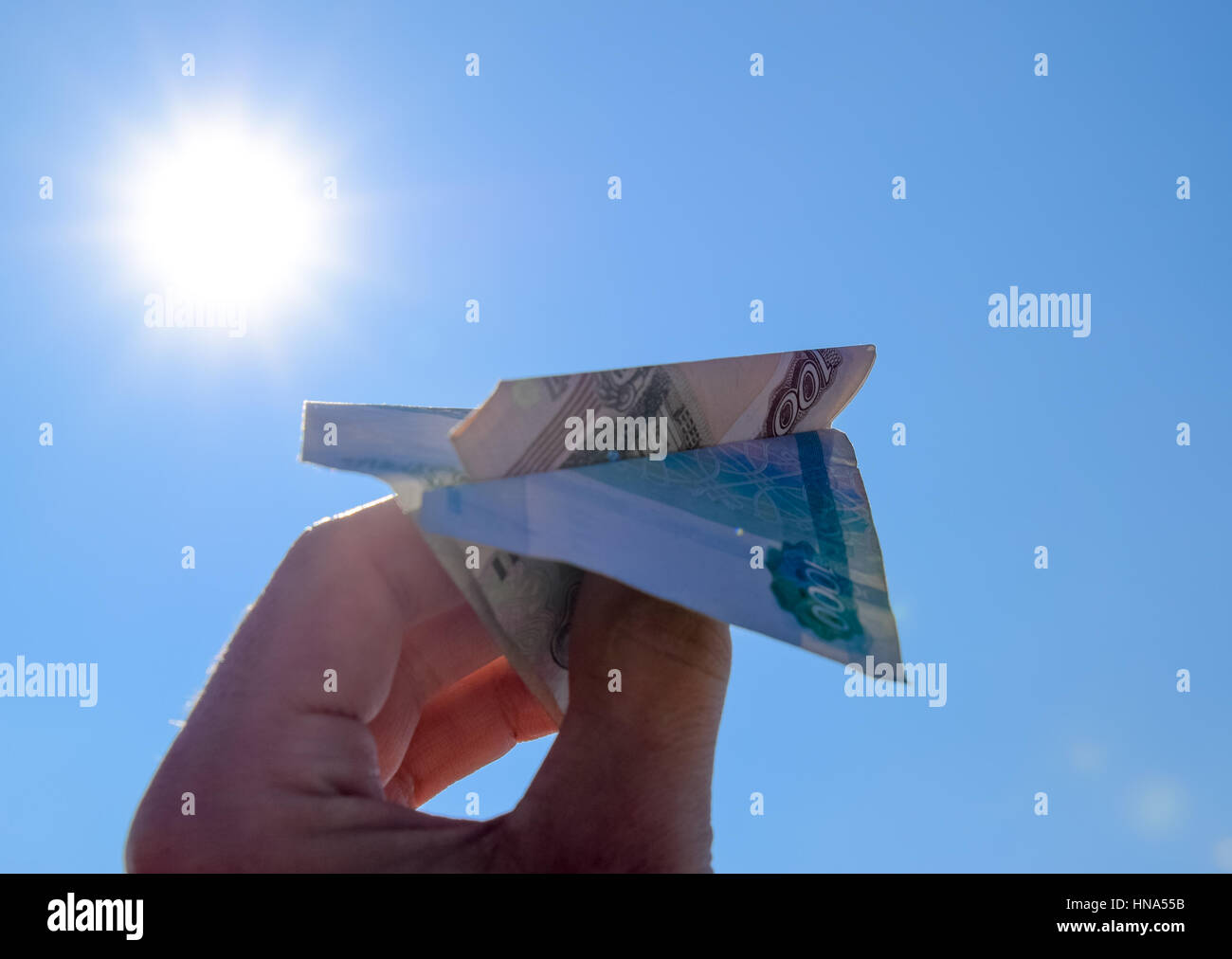 Denominations of Russian money, folded in the airplane against the blue ...