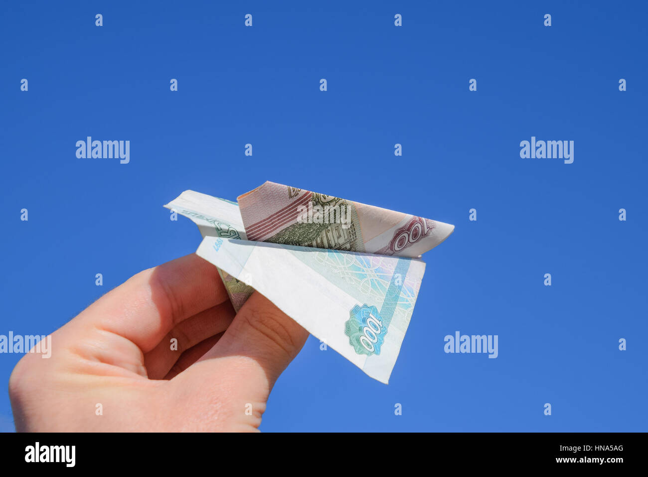 Denominations of Russian money, folded in the airplane against the blue ...