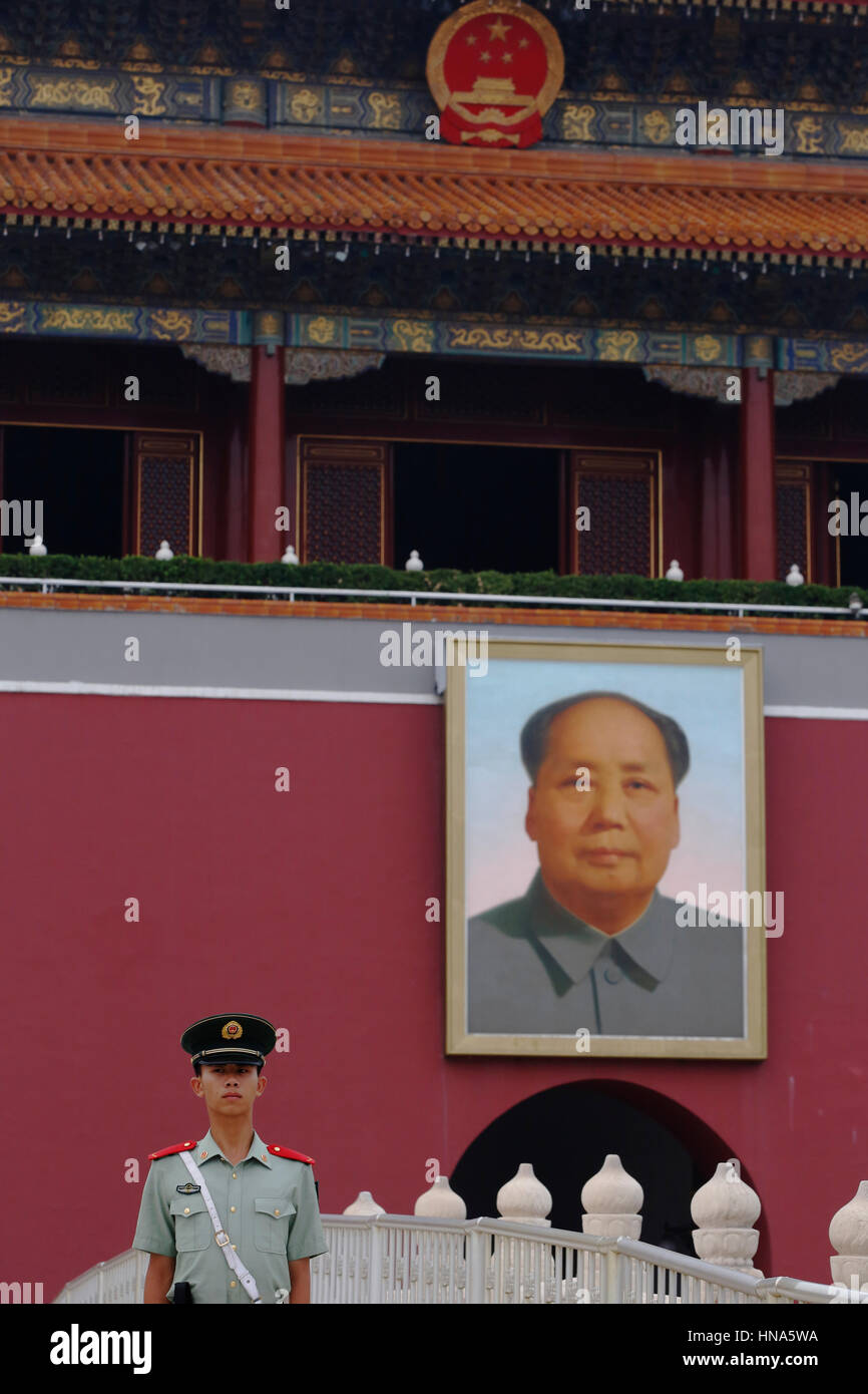 A soldier stands guard, beneath a portrait of Chairman Mao Zedong ...