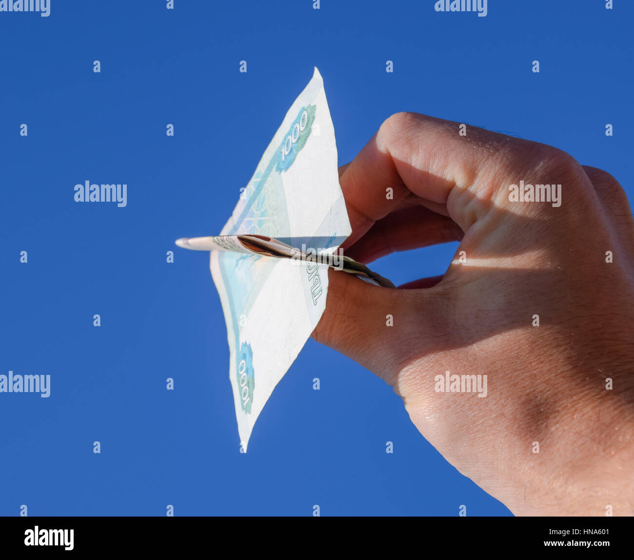 Denominations of Russian money, folded in the airplane against the blue ...