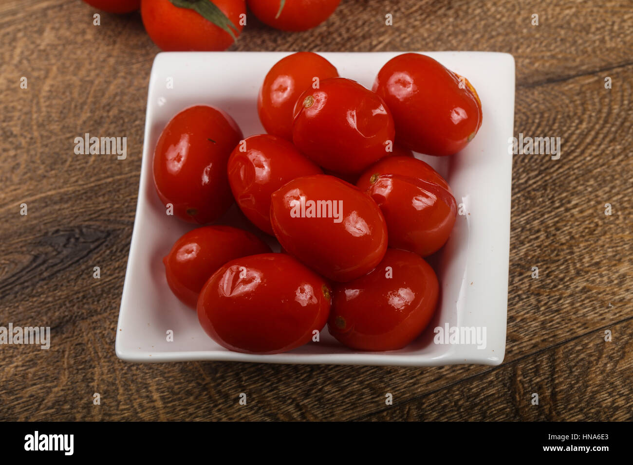 Pickled cherry tomatoes heap on the wooden background Stock Photo - Alamy