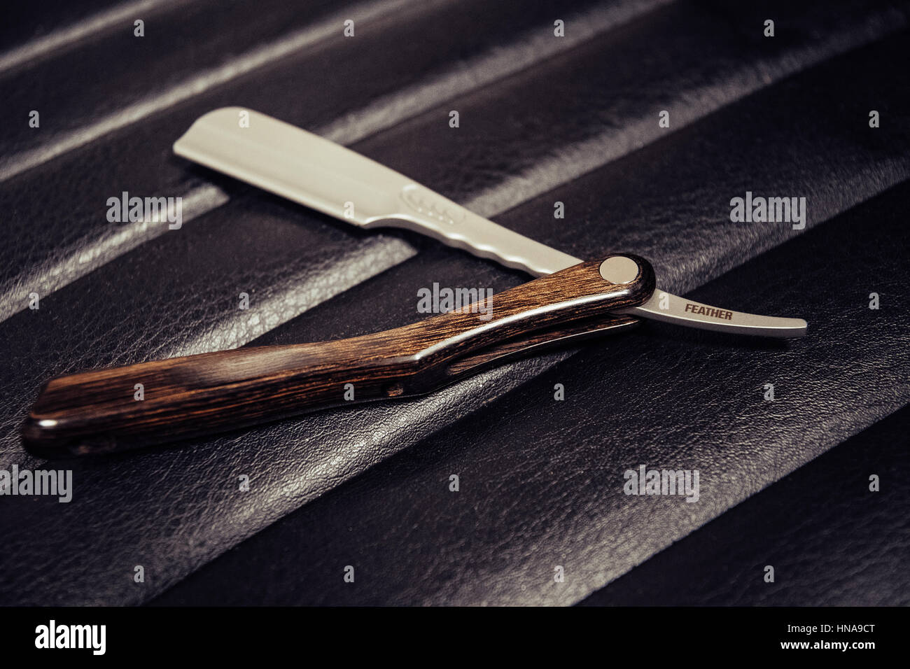 Shavette razor on a black leather chair with wood textured handle Stock ...