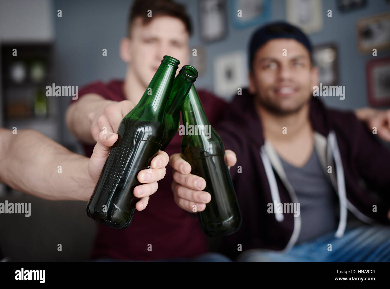 Guys toasting with beer bottles Stock Photo - Alamy