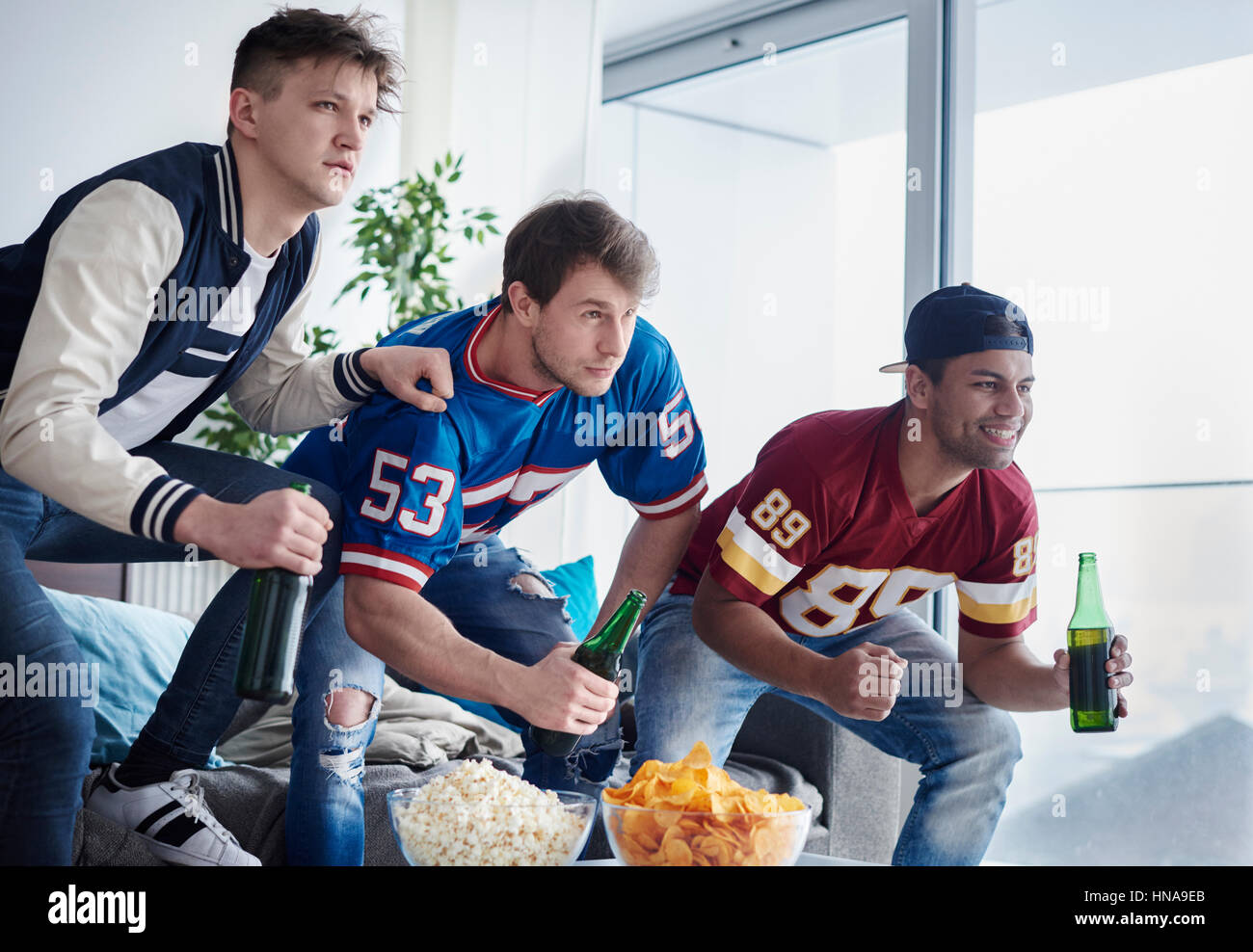 Eager sports fans on the living room Stock Photo - Alamy