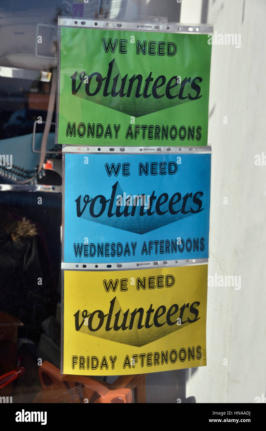 Advertisement for volunteers in a charity shop window Stock Photo - Alamy