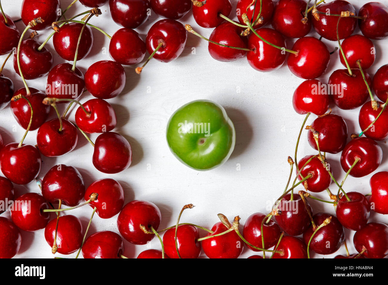 cherries isolated on white background geen plum in the middle Stock ...