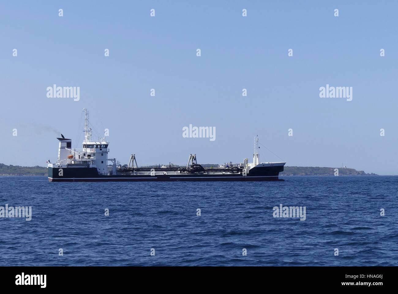 Tanker ship awaiting at anchorage with coastal landscape in background ...
