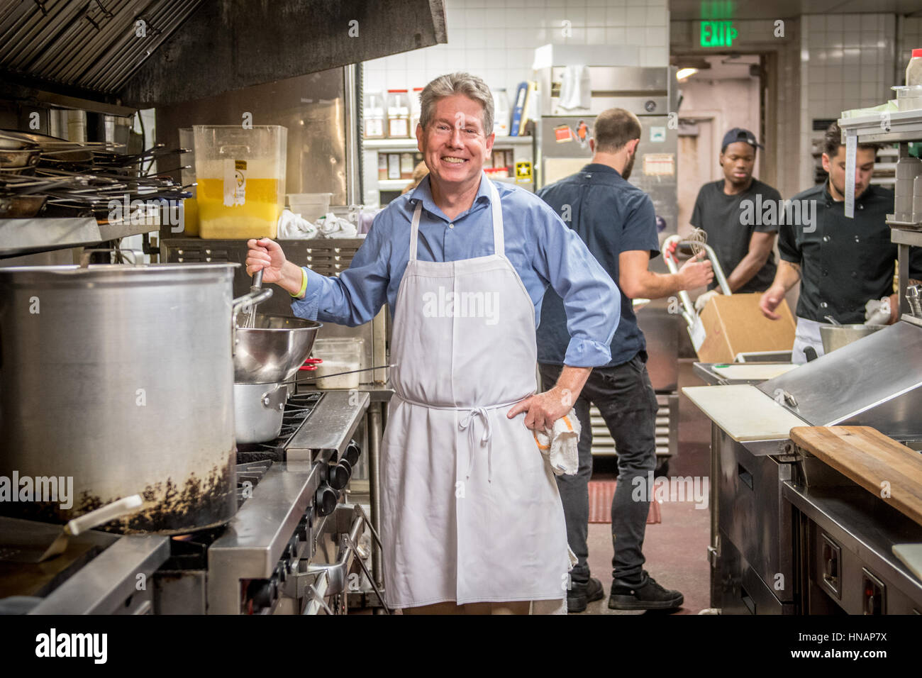 Chef poses for a photograph while mixing ingredients in a pot at ...
