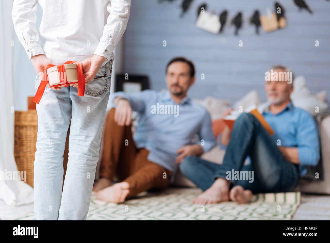 Nice young boy holding a present behind his back Stock Photo - Alamy