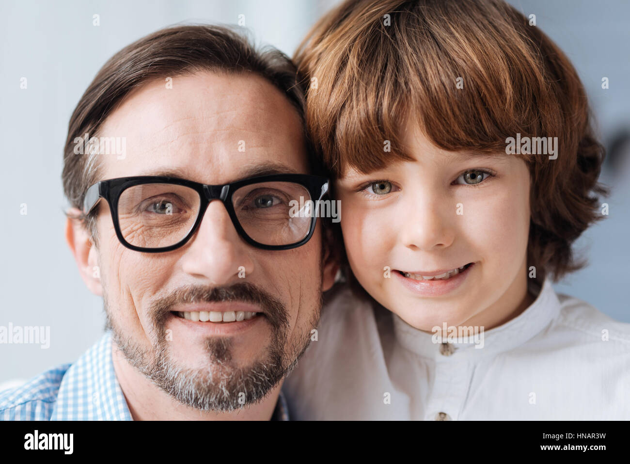 Happy delighted father and son standing together Stock Photo - Alamy