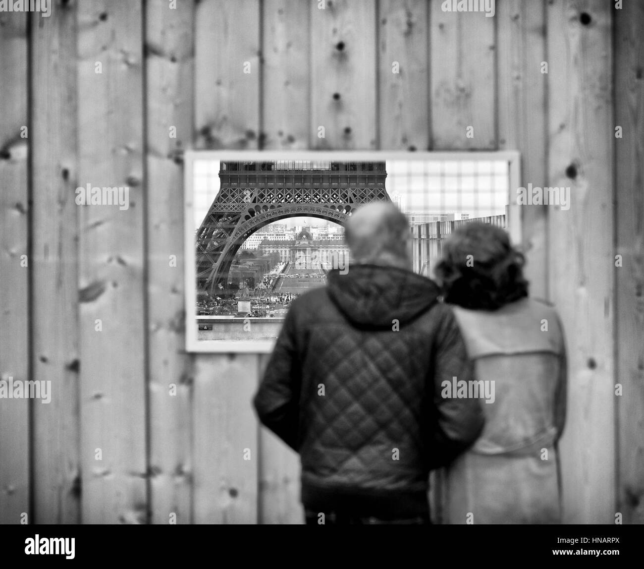 A couple take in the somewhat obstructed views of the Eiffel Tower from ...