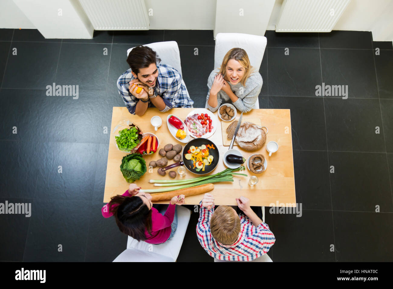 Group of young people having meal in the modern kitchen, view from ...