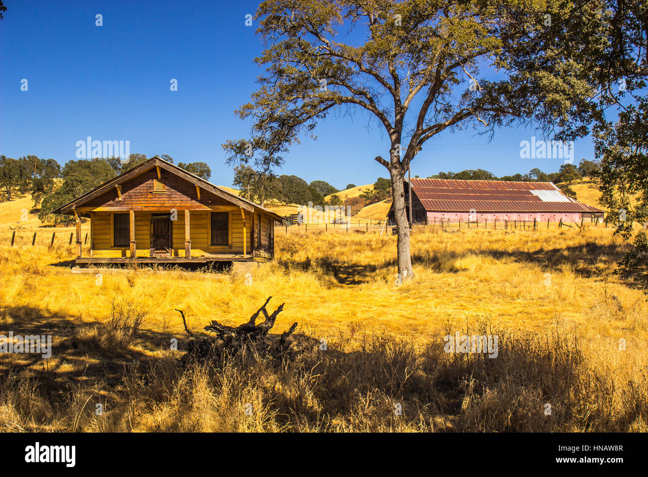 Old Abandoned Yellow Farm House With Large Barn In Background Stock ...