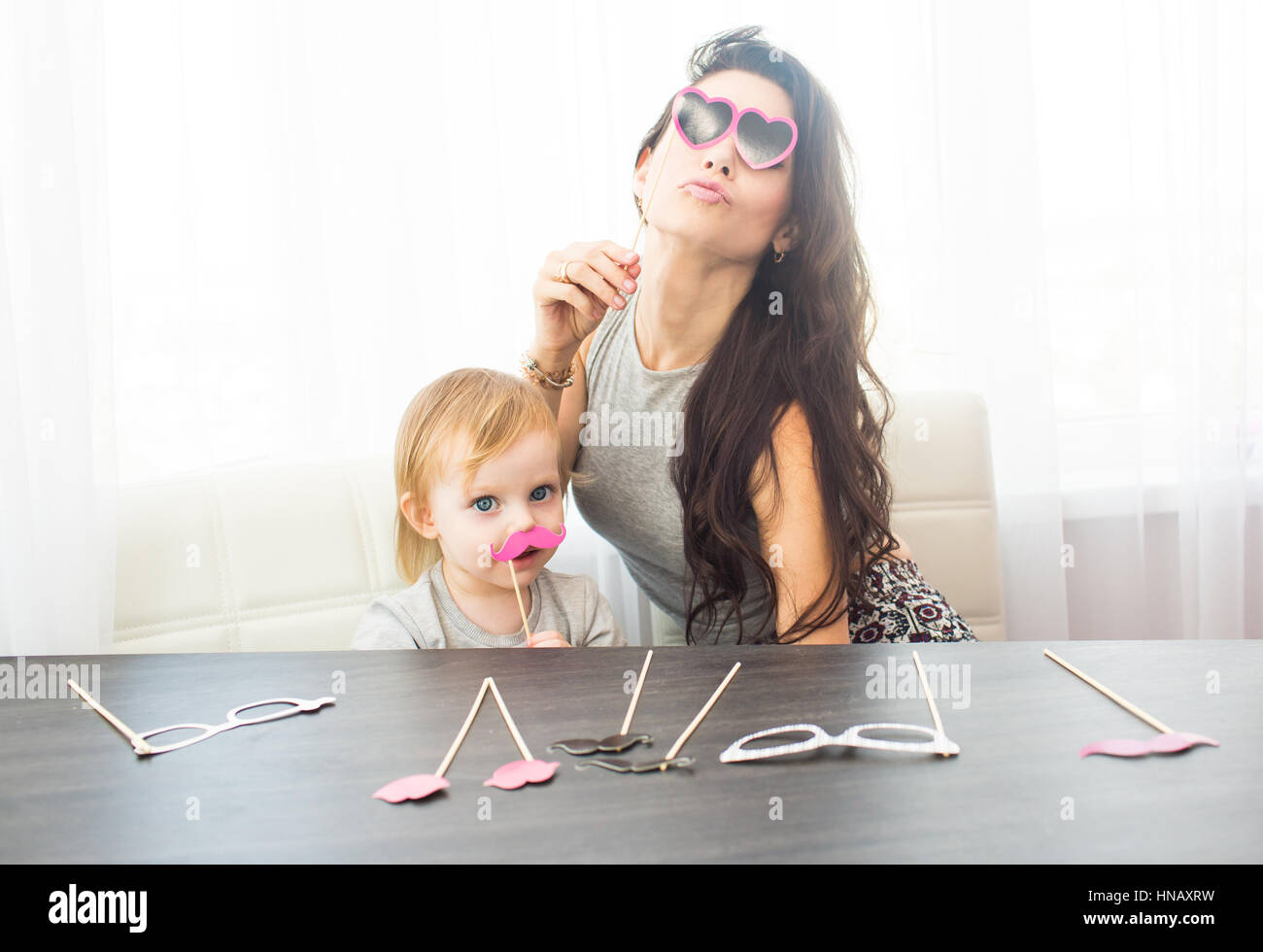 Funny family. Mother and her child daughter girl with a paper ...