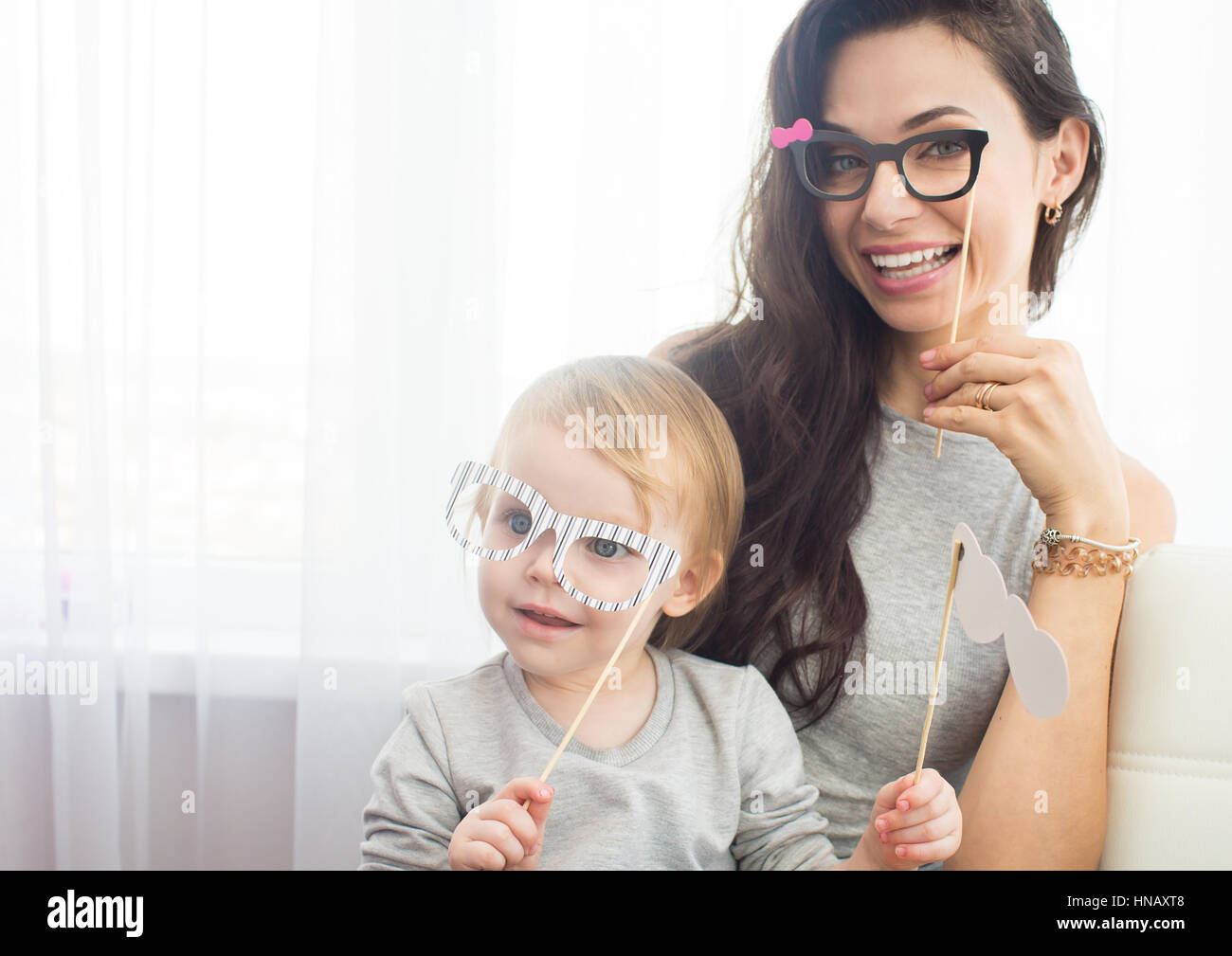 Funny family. Mother and her child daughter girl with a paper ...