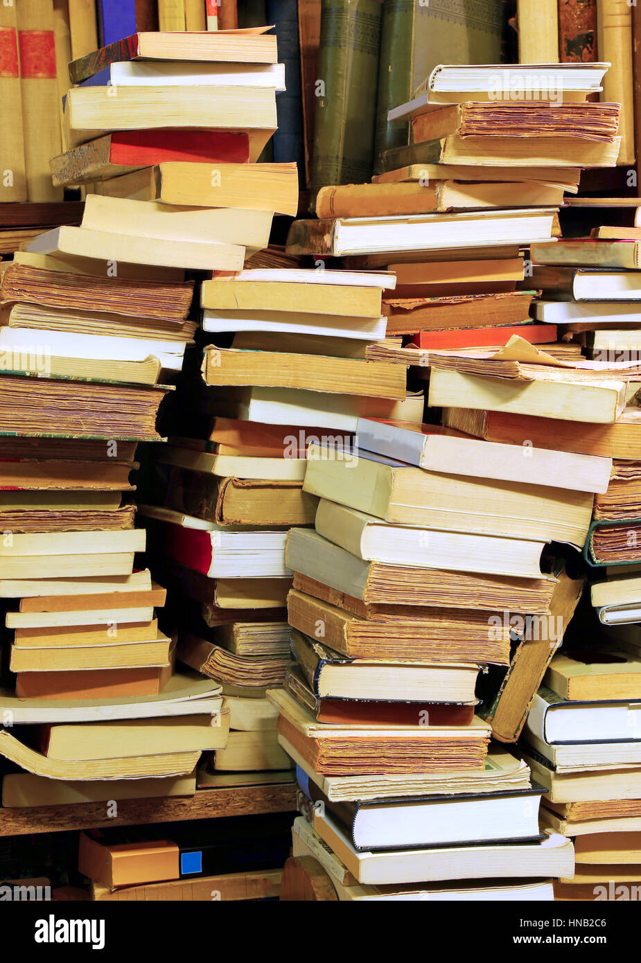 many piles of old books for sale in an old library Stock Photo - Alamy