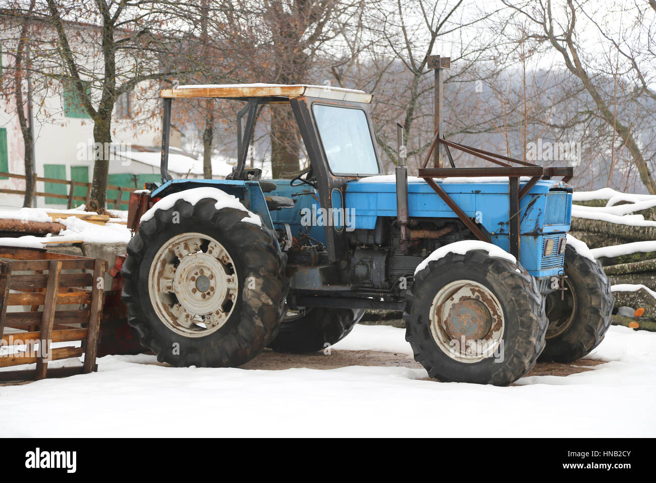 Blue old tractor on a farm in winter with snow Stock Photo - Alamy