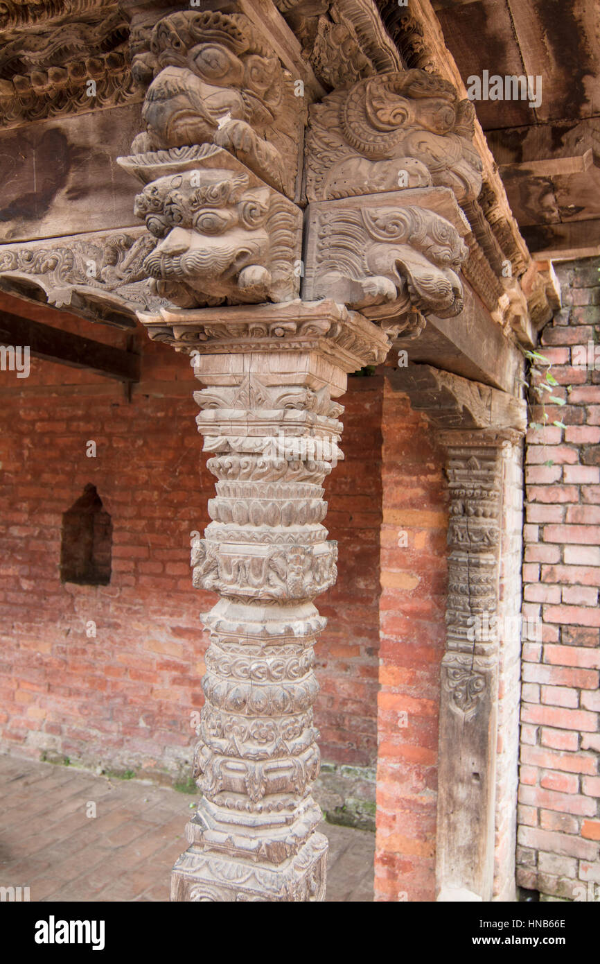 Intricately carved wooden post in traditional Nepali style of an old ...