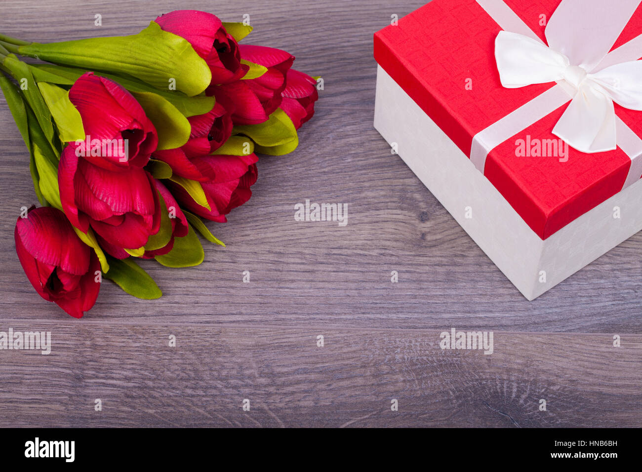 Beautiful tulips and gift on a wooden background Stock Photo - Alamy