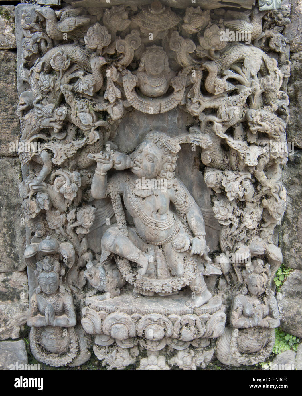 Stone carving of a Hindu god blowing a conch surrounded by celestial ...
