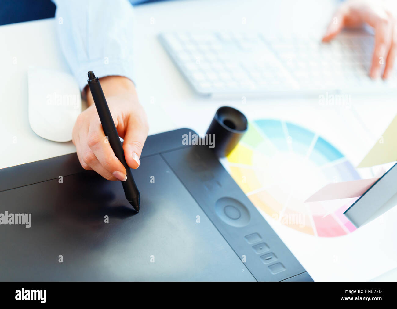 Female artist drawing something on graphic tablet at the home office ...