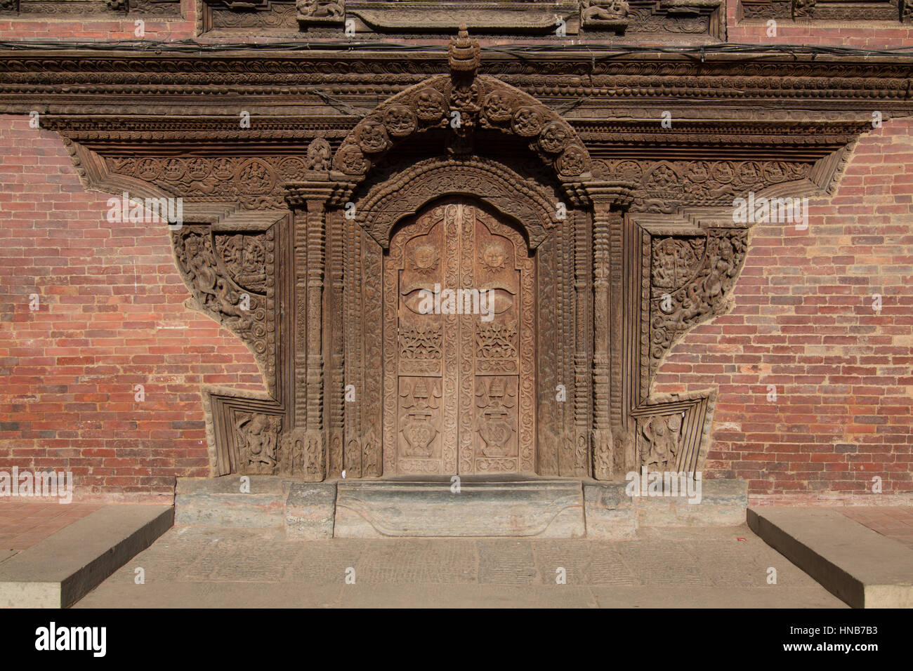 A richly carved wooden door adorned with figures of Hindu gods and ...