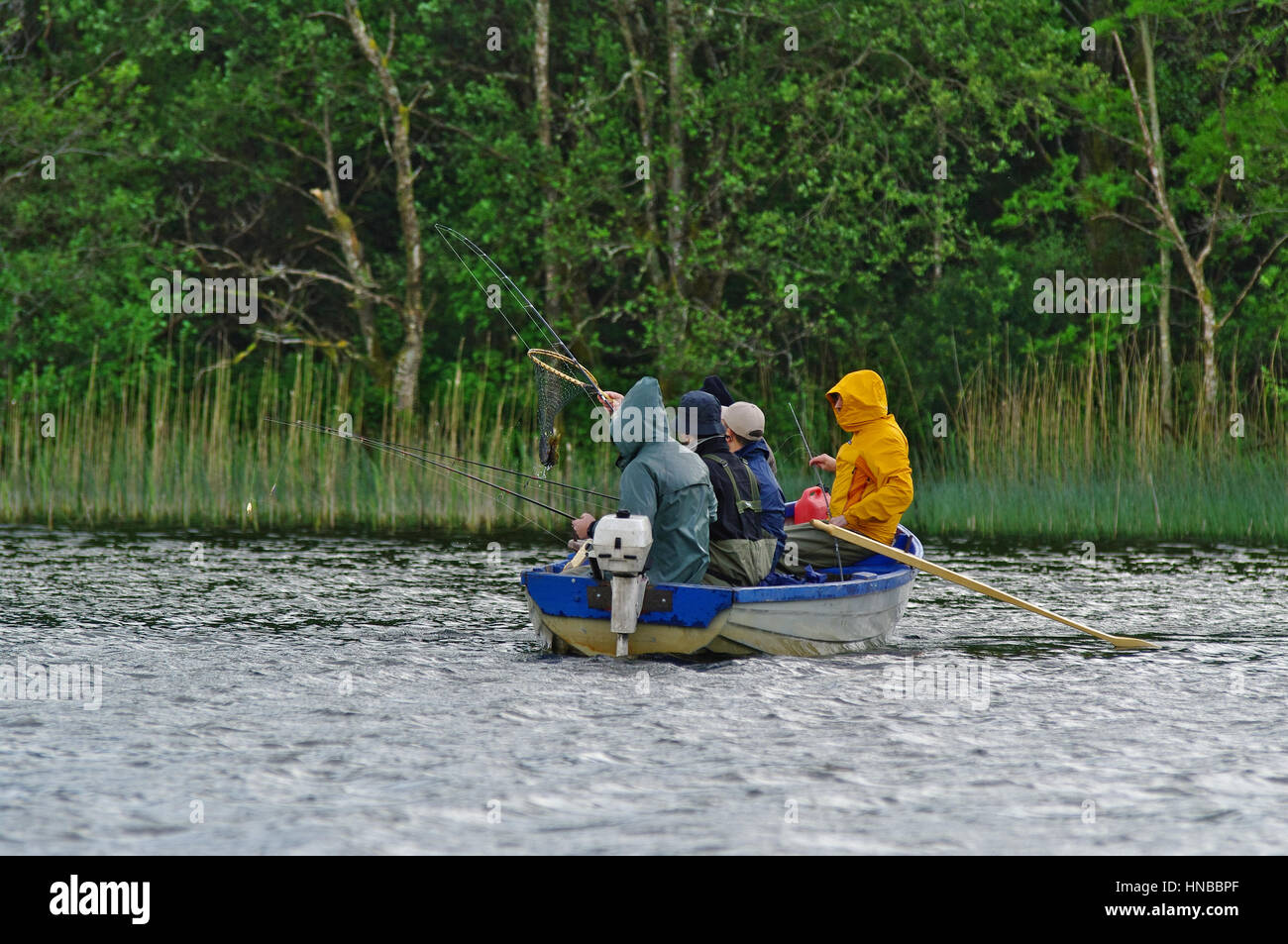 CASTLEBAR,IE - CIRCA MAY, 2011 - Four people fishing from a boat in a ...