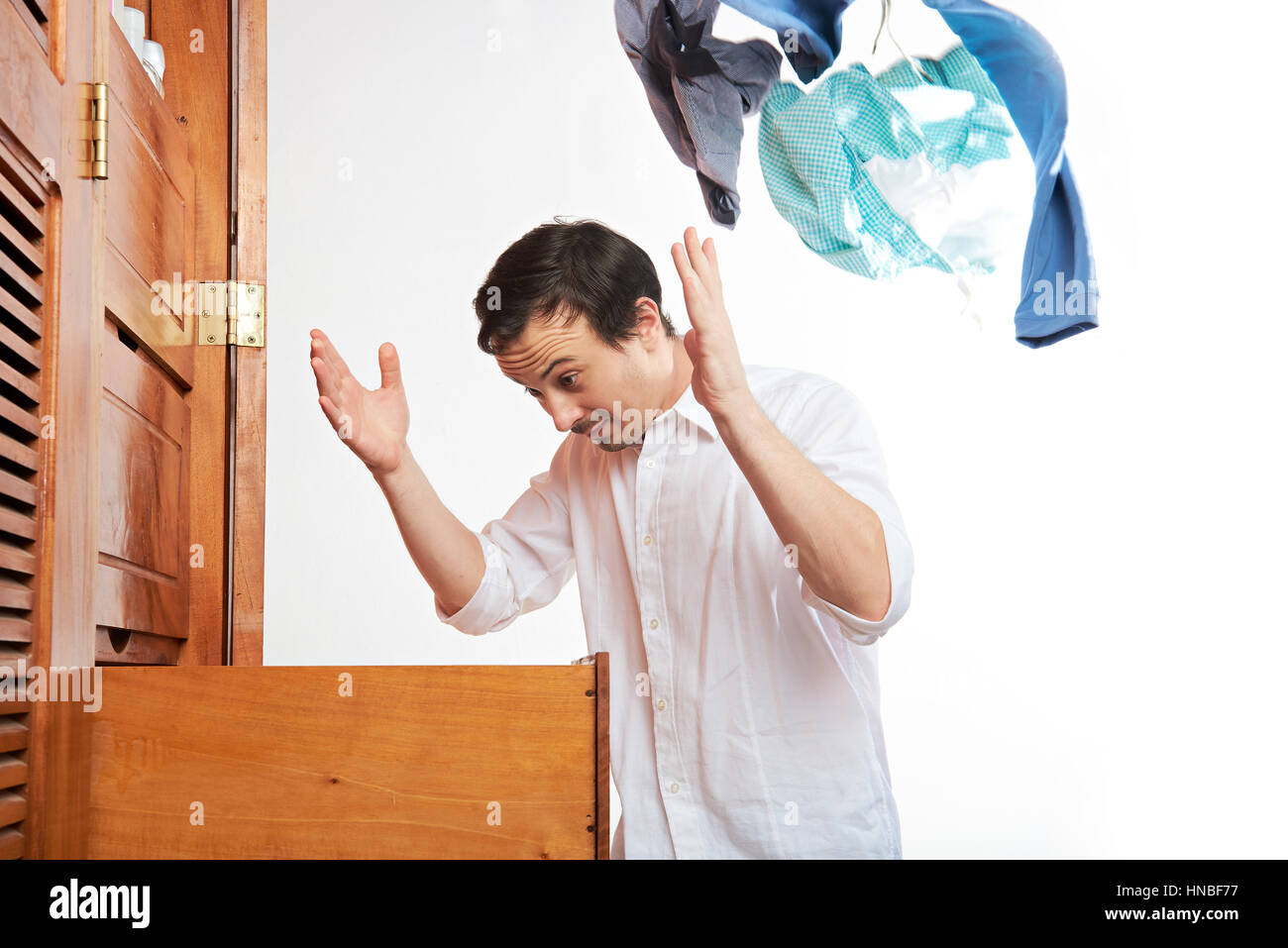 young man throwing clothes from wardrobe isolated on white Stock Photo ...