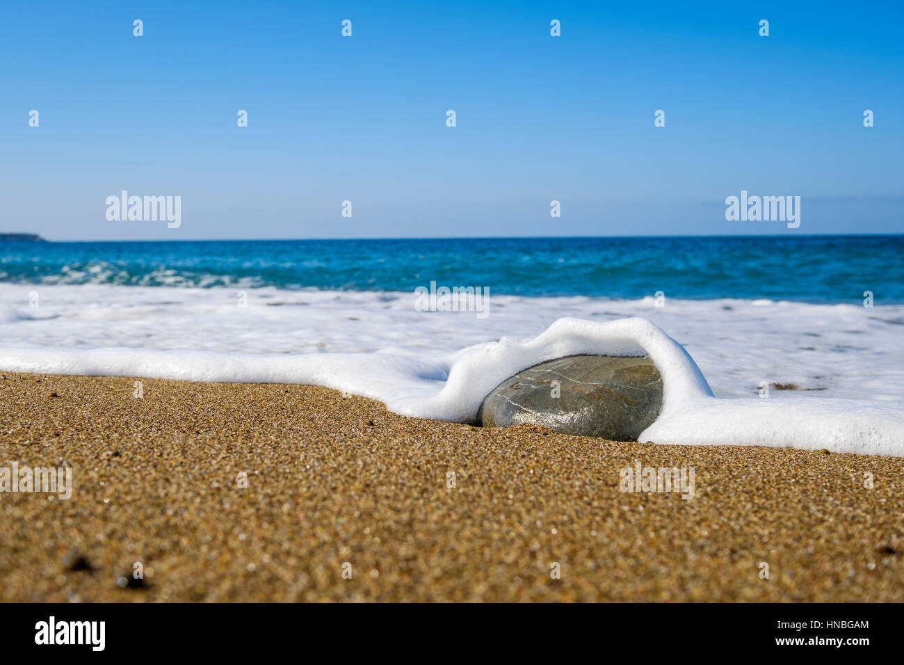 wave of water bounce against a stone on the beach Stock Photo - Alamy