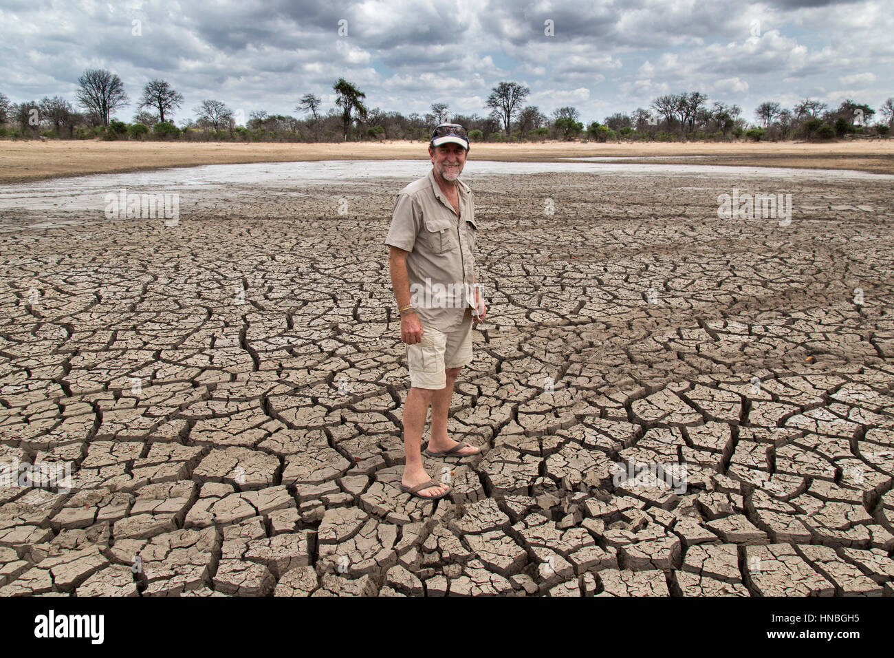 Scenic view of a man standing on the caked, dried out mud at a ...